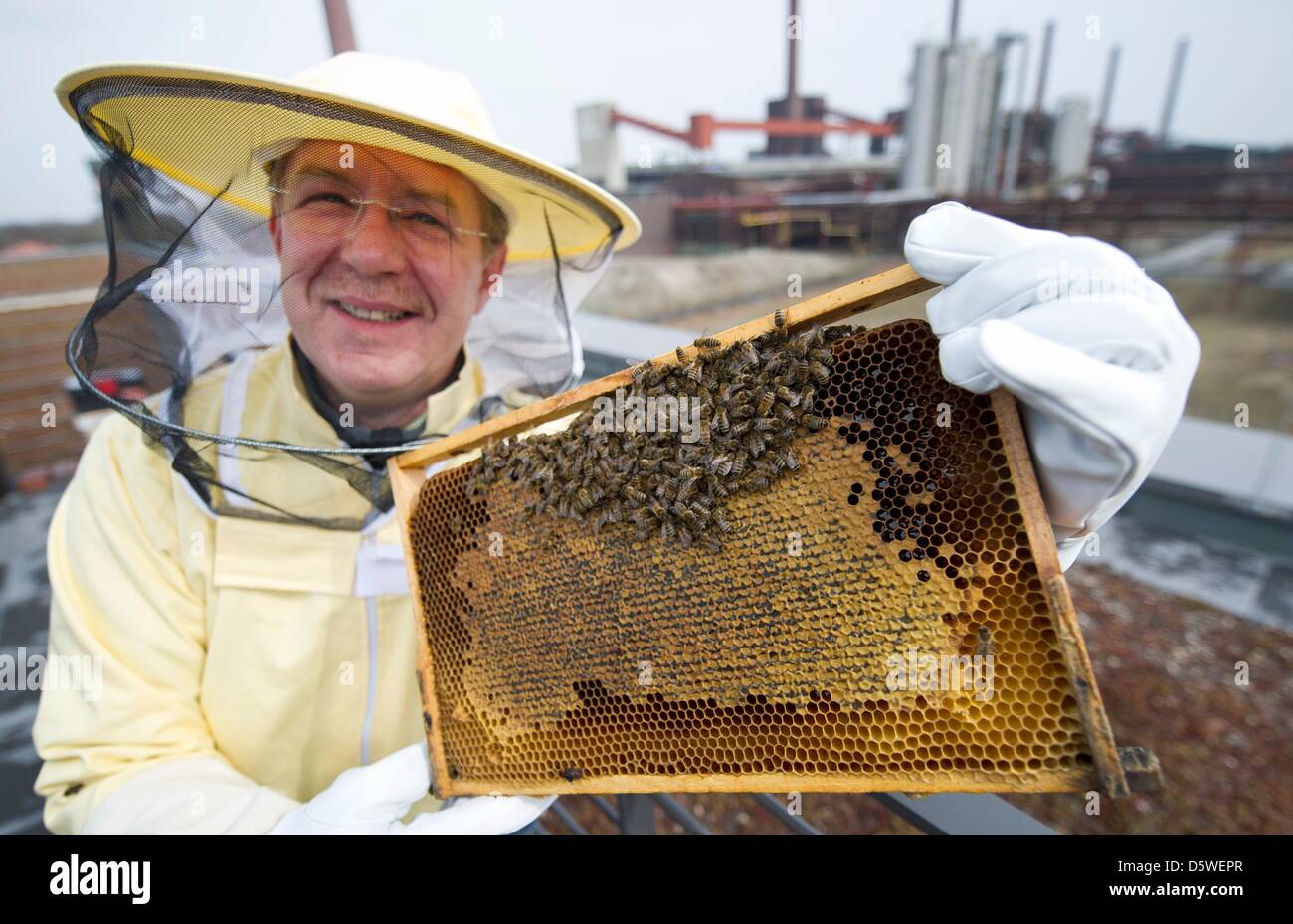 Beekeeper and RAG employee Oliver Haeckel holds a beehive on the roof ...