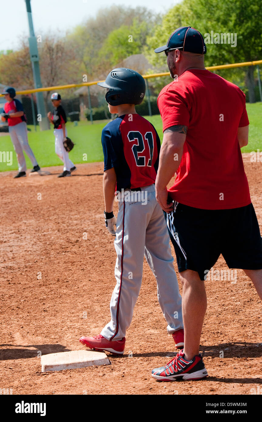 Teen baseball player and baseball coach at first base Stock Photo - Alamy