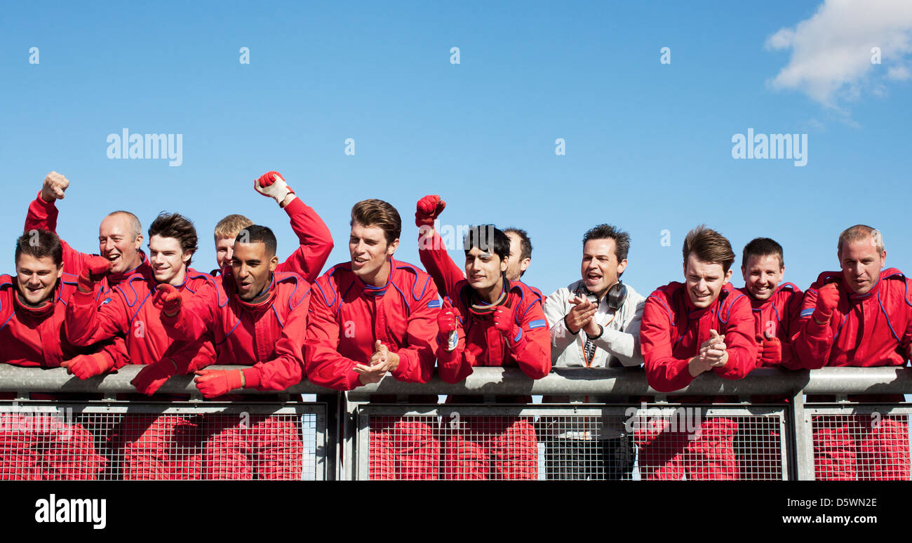 Racing team cheering on sidelines Stock Photo - Alamy