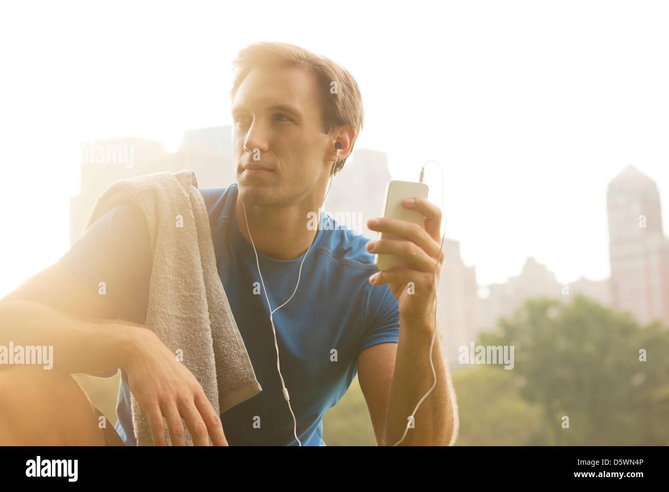 Runner listening to mp3 player in park Stock Photo - Alamy