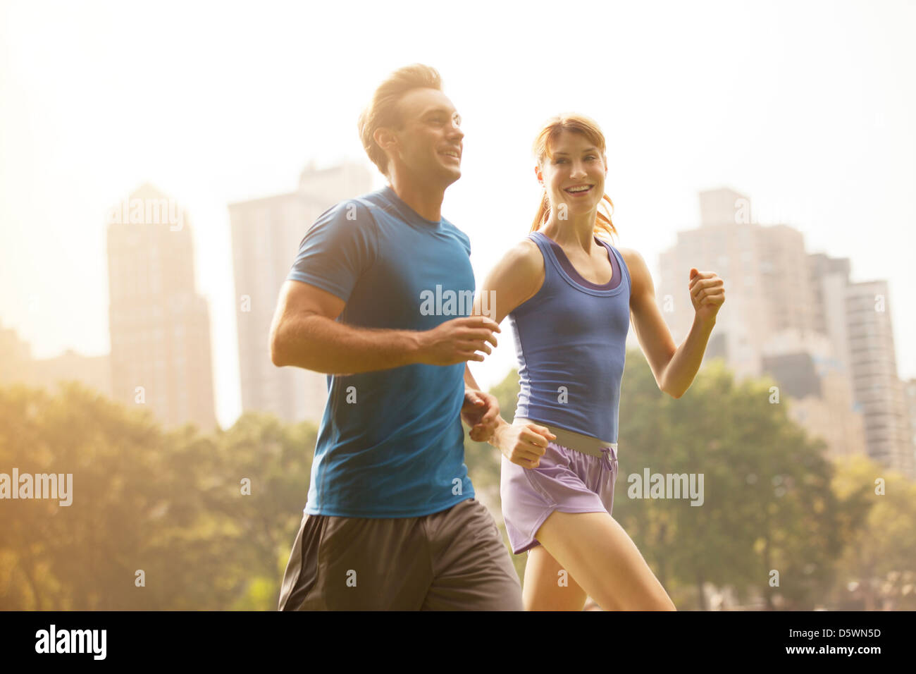 Couple running in urban park Stock Photo - Alamy