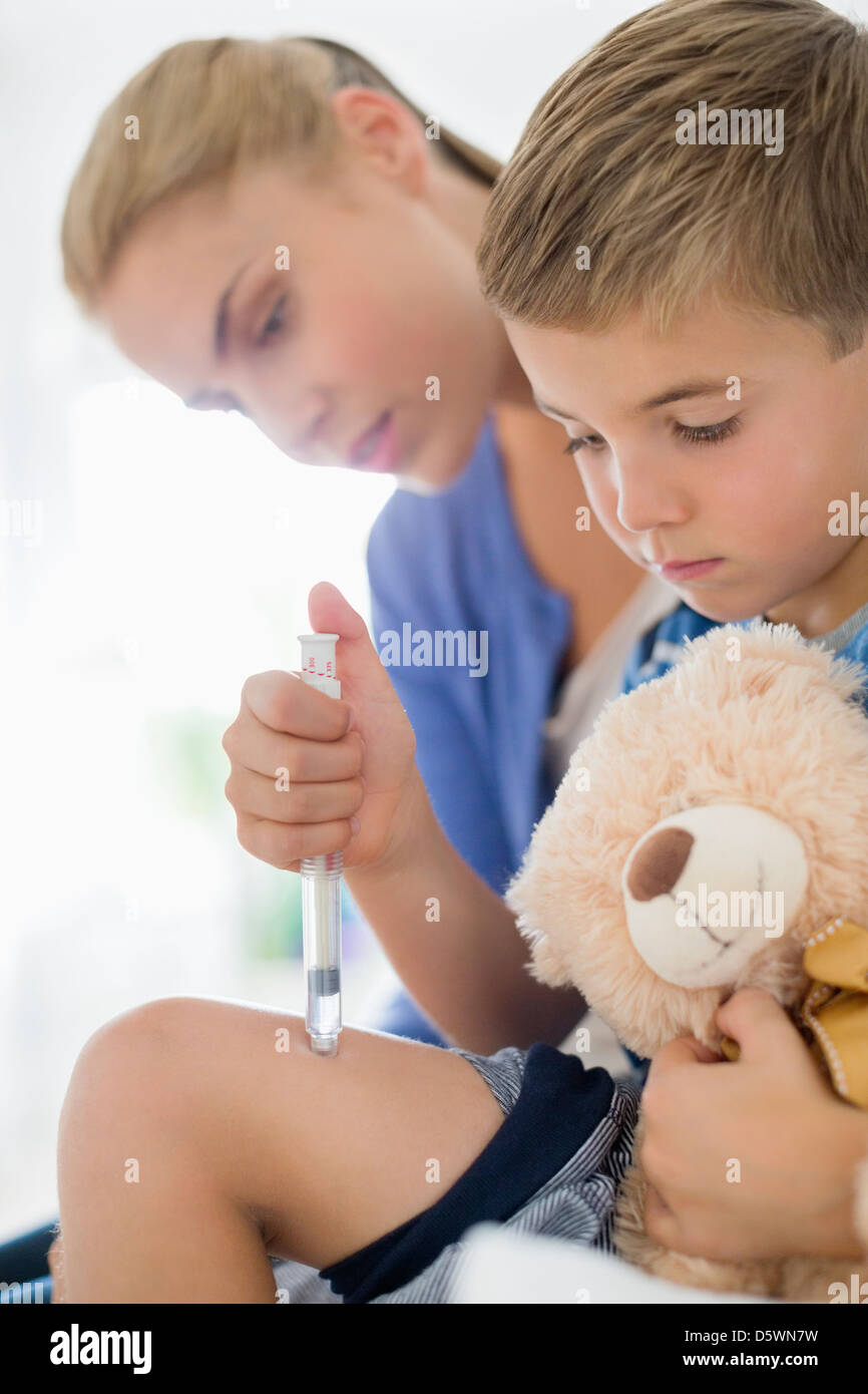 Mother giving son injection in leg Stock Photo - Alamy