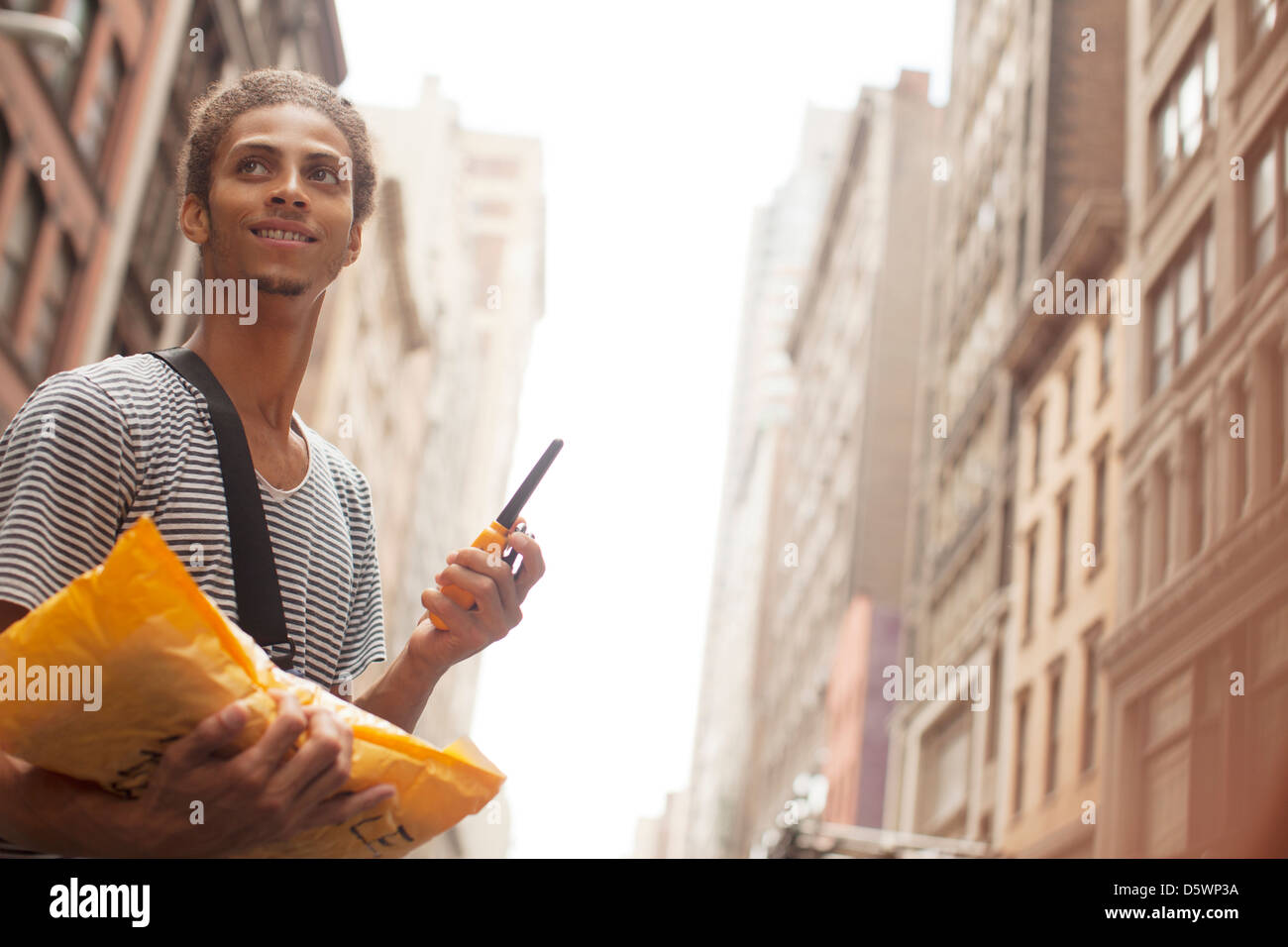 Man carrying mail on city street Stock Photo - Alamy