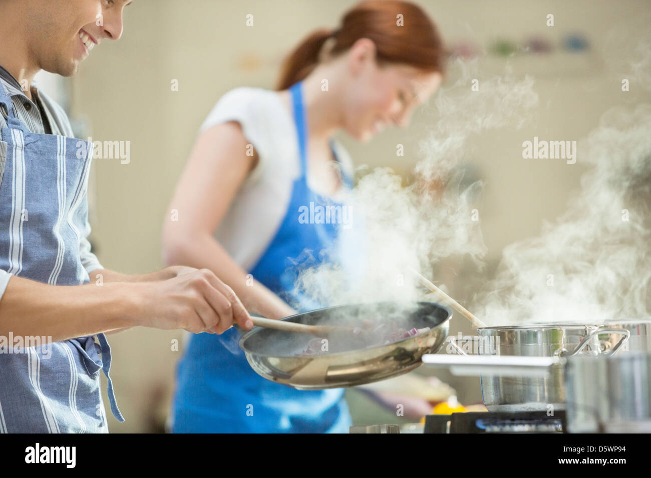 Couple cooking in kitchen Stock Photo - Alamy