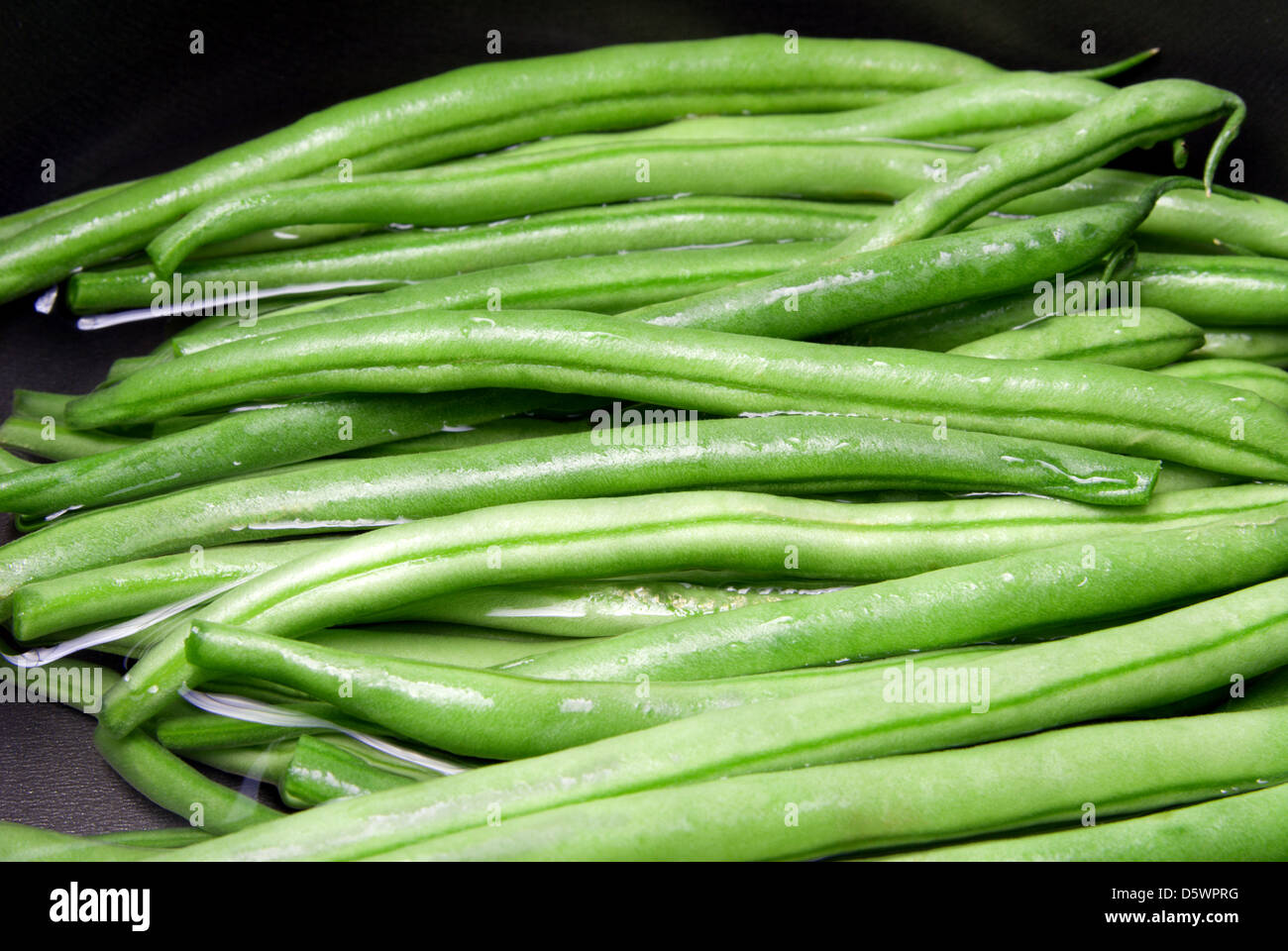 Boiling green beans in a black pan Stock Photo - Alamy