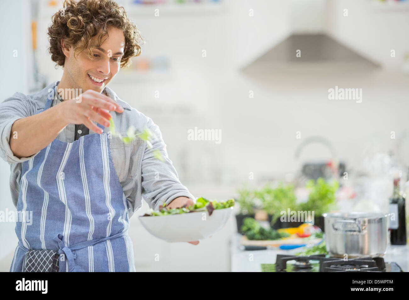 Man making salad in kitchen Stock Photo - Alamy