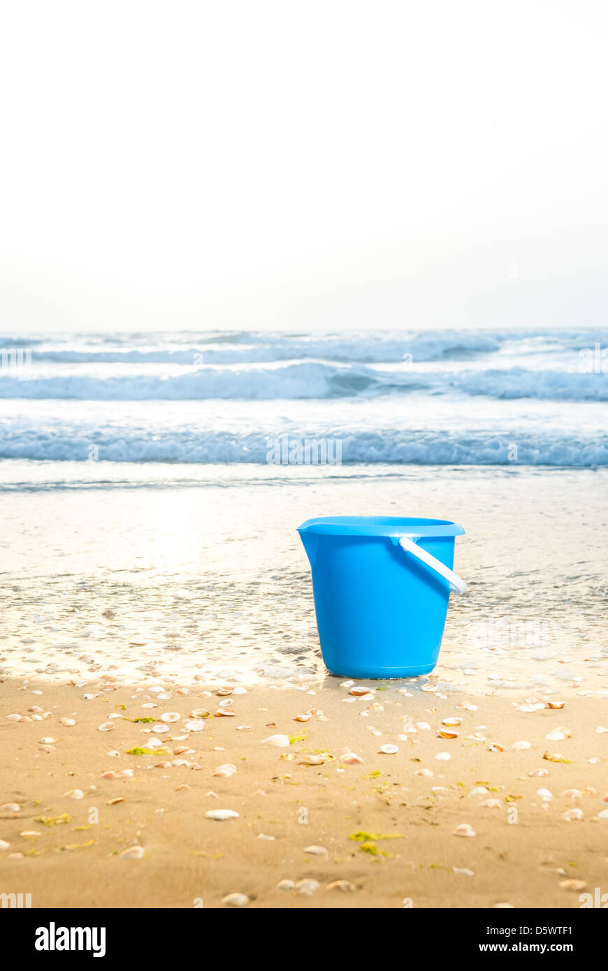 Blue bucket standing on sand at the beach at sunset Stock Photo - Alamy