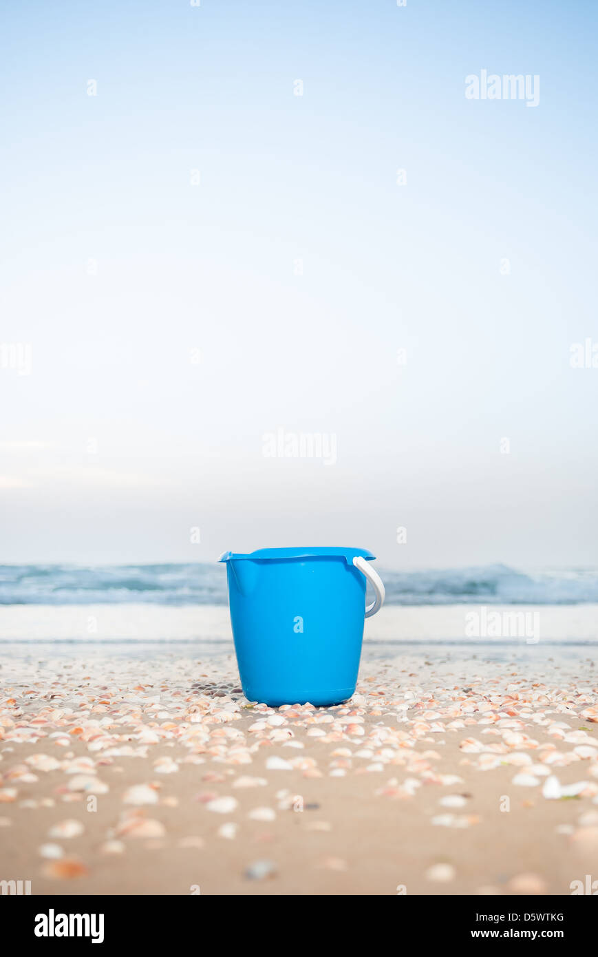 Blue bucket standing on sand at the beach at sunset Stock Photo - Alamy