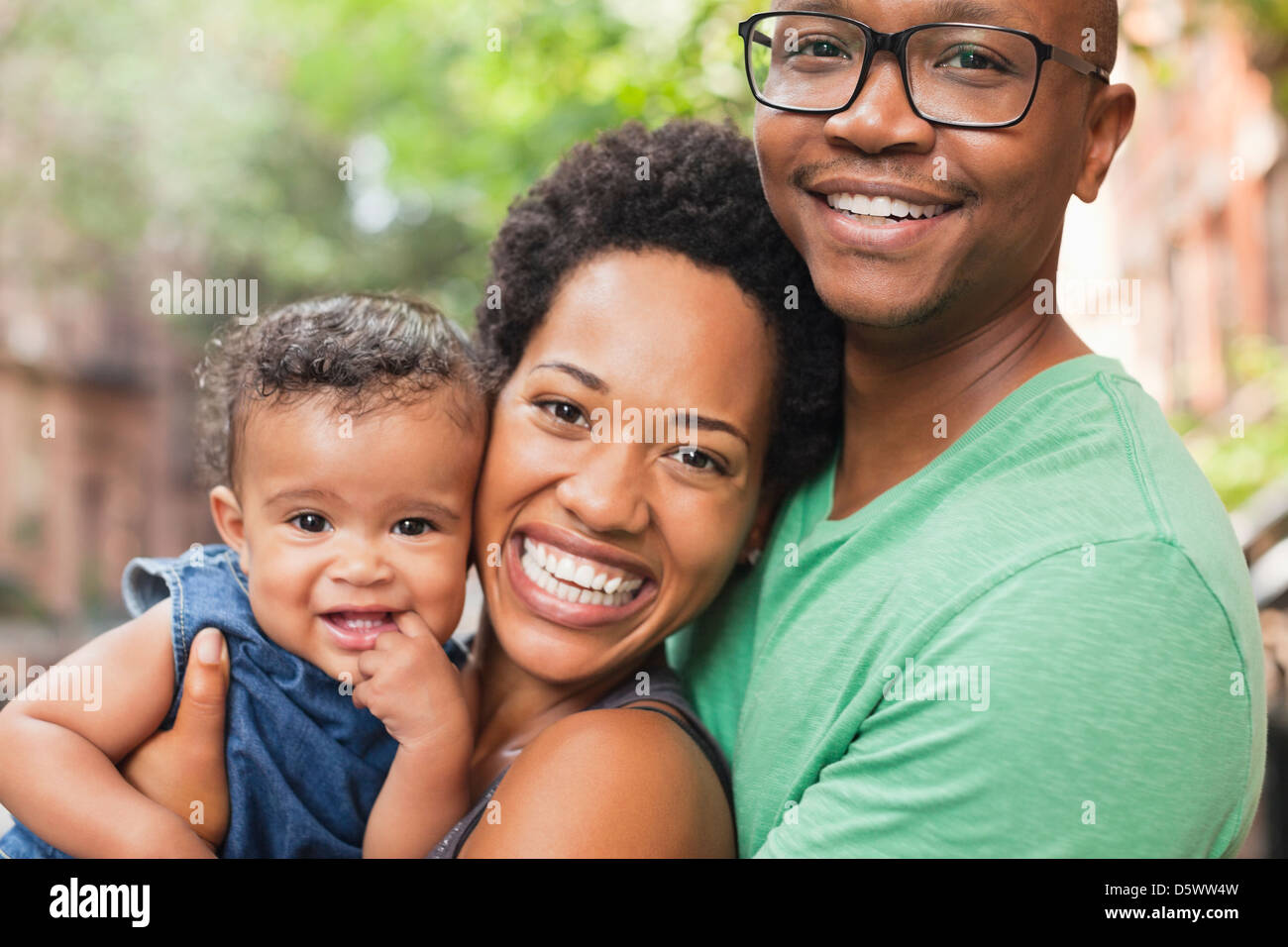 Family smiling together on city street Stock Photo - Alamy