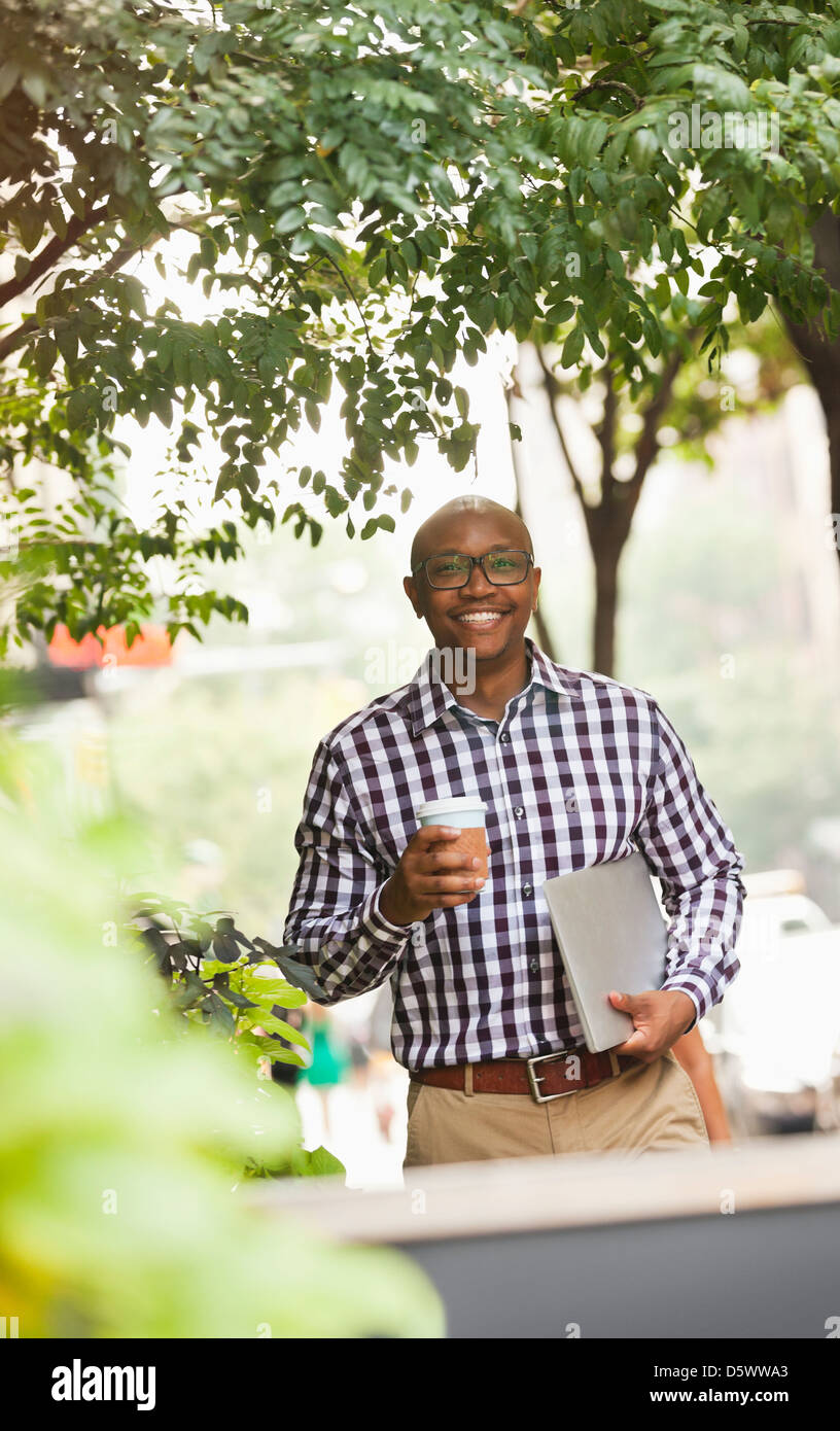 Man carrying laptop on city street Stock Photo - Alamy
