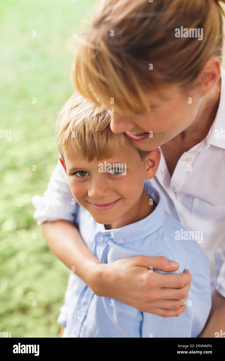 Mother hugging son in park Stock Photo - Alamy