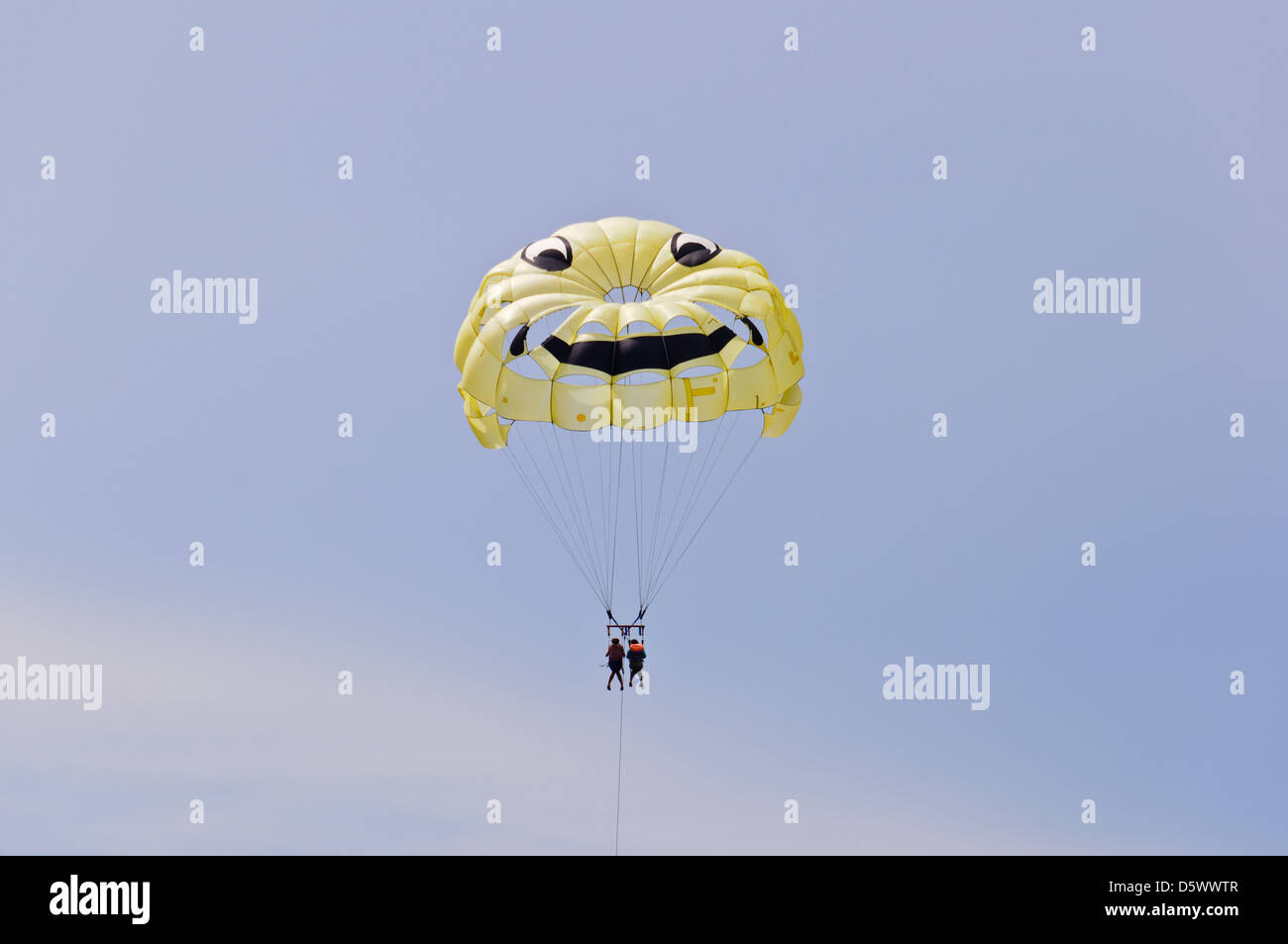 Parasailing – 2 girls paragliding with yellow parachute with Smiley ...