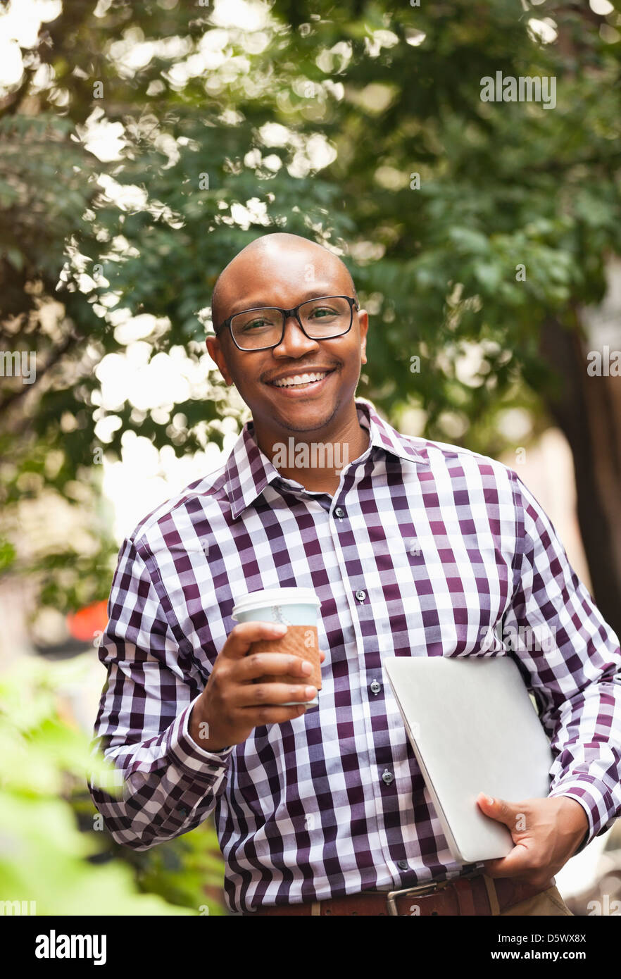 Man carrying laptop on city street Stock Photo - Alamy