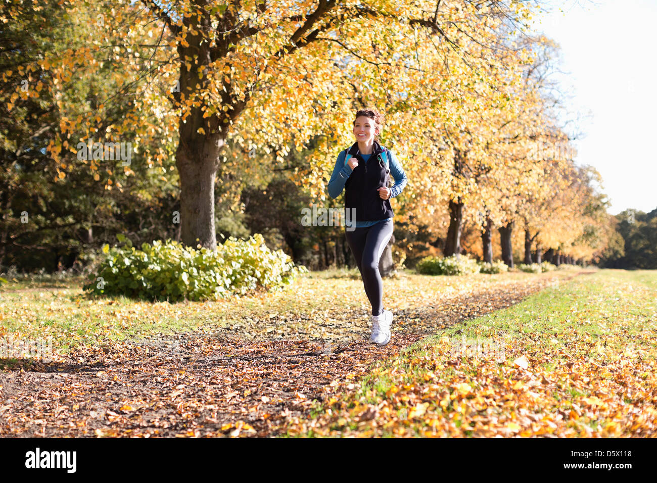 Woman running in park Stock Photo - Alamy