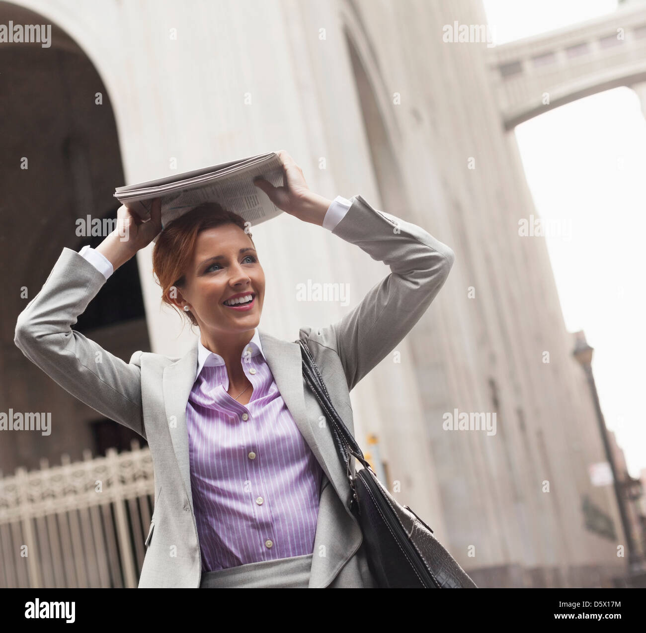Businesswoman covering hair with newspaper Stock Photo - Alamy