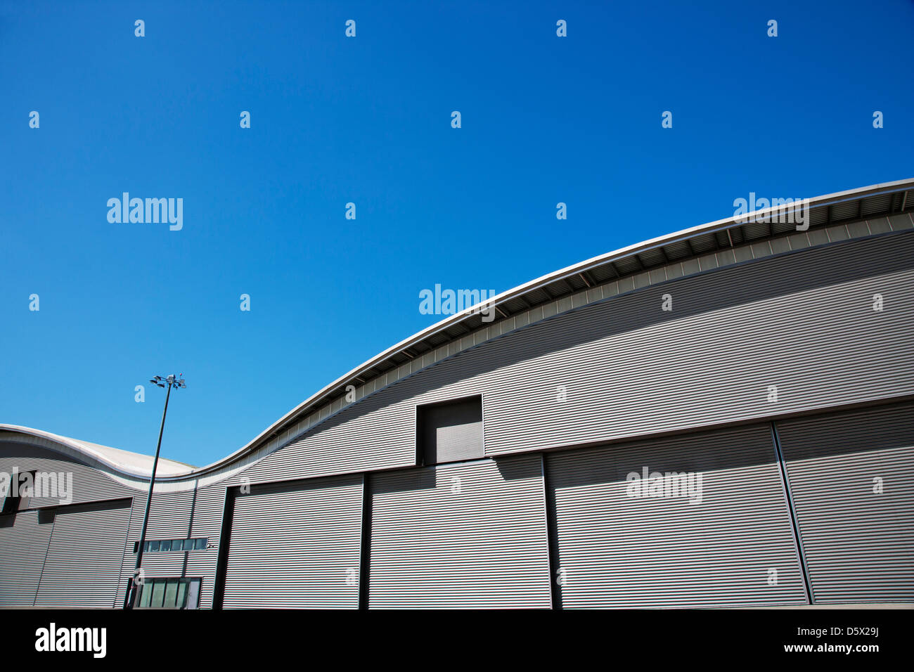 Curved roof of warehouse and blue sky Stock Photo - Alamy