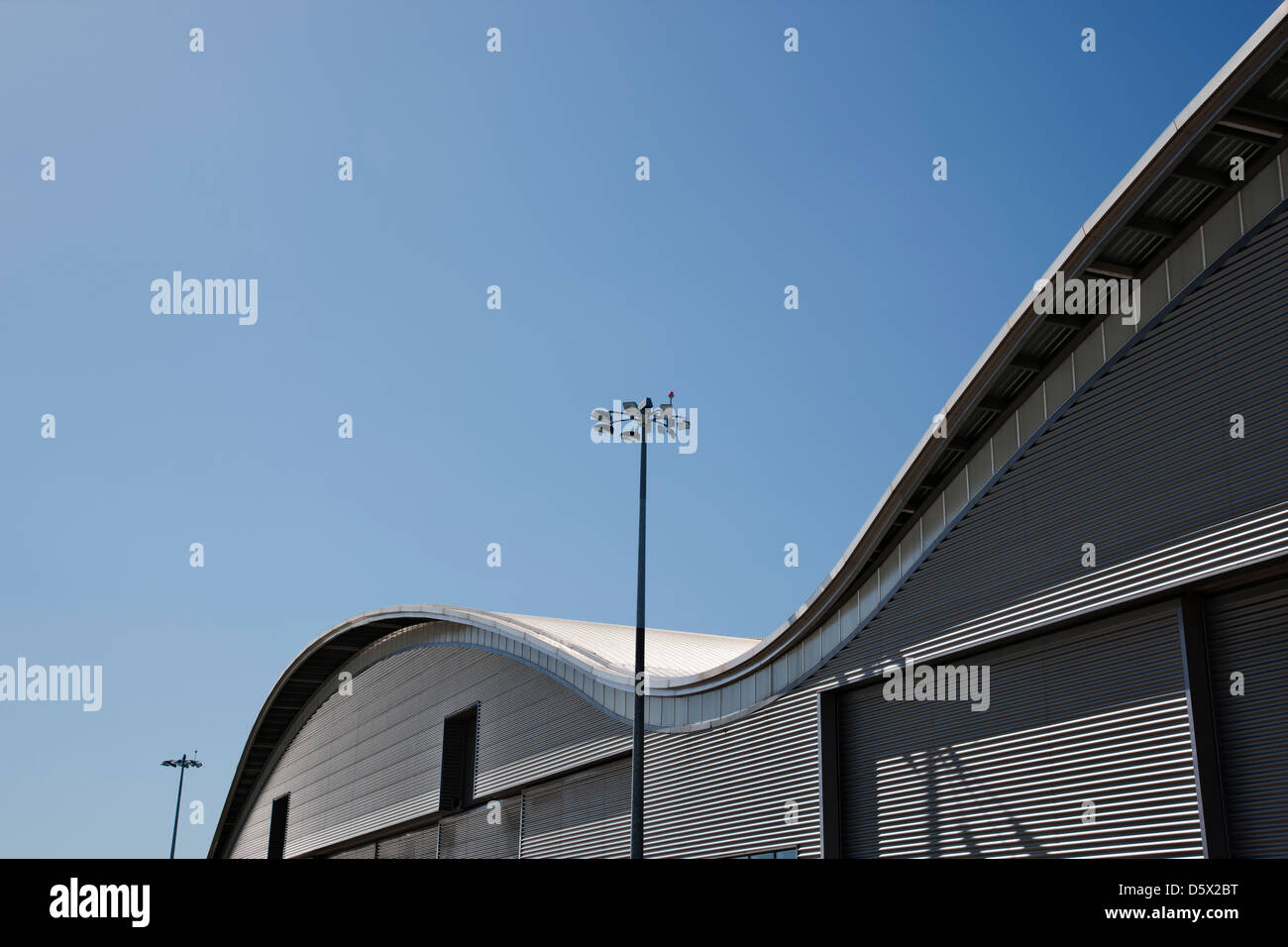 Curved roof of warehouse and blue sky Stock Photo - Alamy