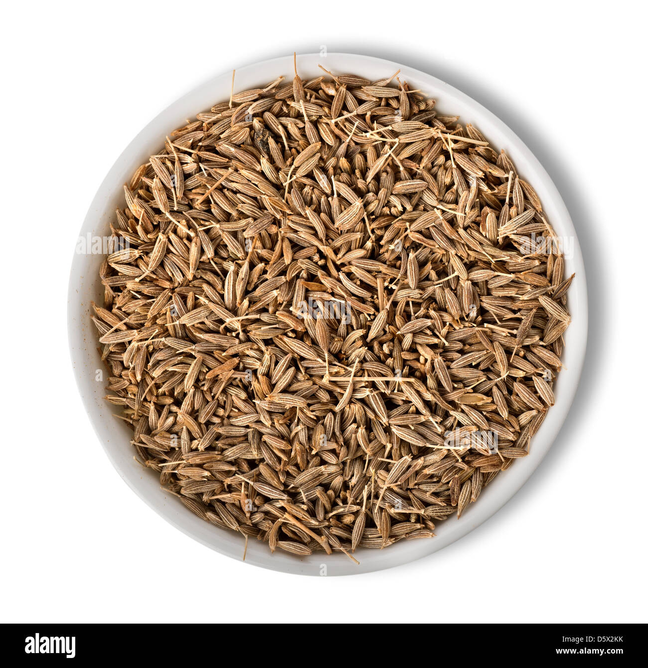 Cumin in plate isolated on white background Stock Photo - Alamy