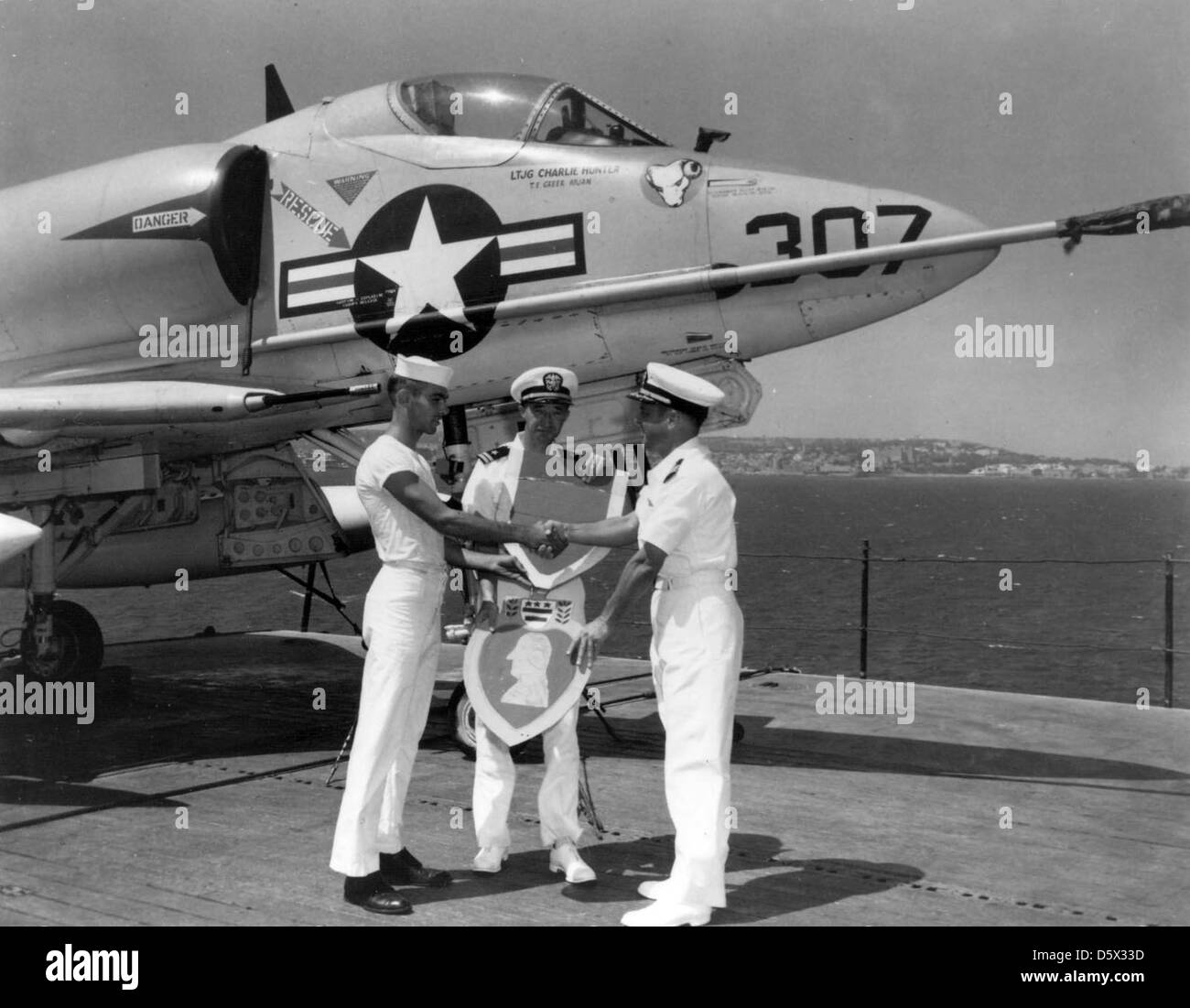Aboard the USS ESSEX (CVA-9), a large Purple Heart is presented to the ...