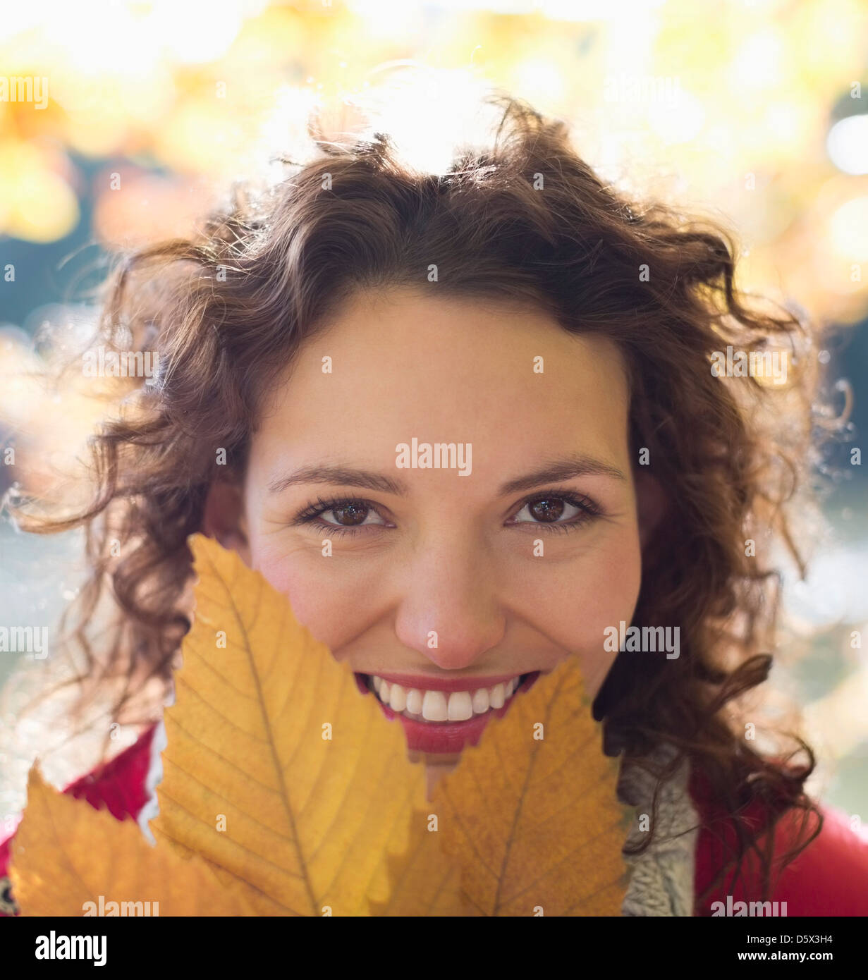 Smiling woman holding autumn leaf Stock Photo - Alamy