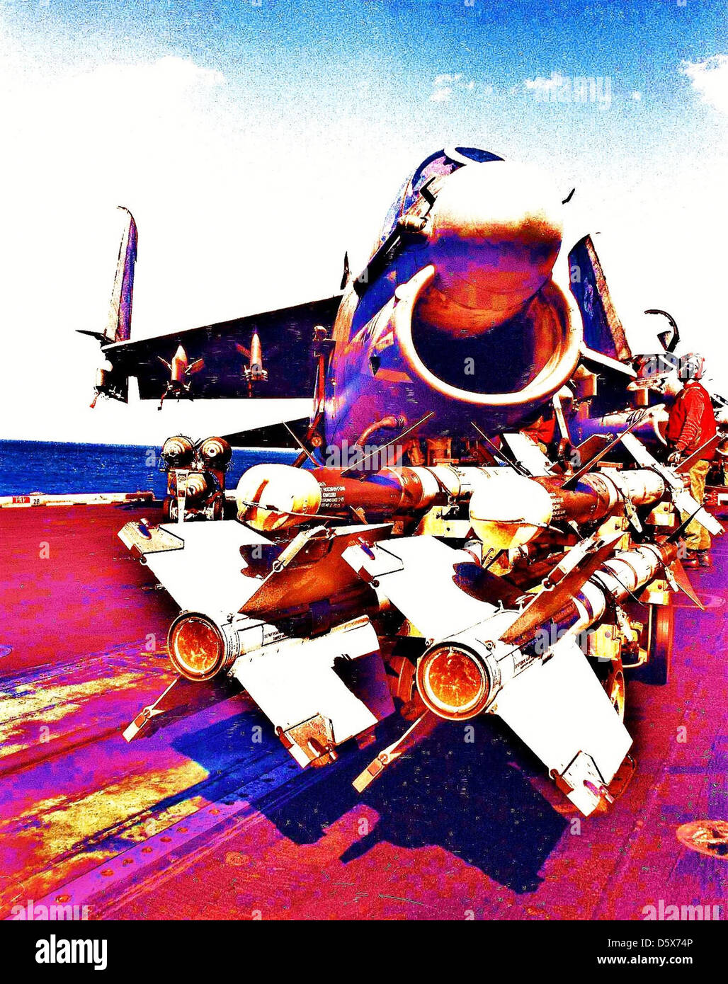 AIM-9 Sidewinder missiles are shown on a cart, prepared for loading ...