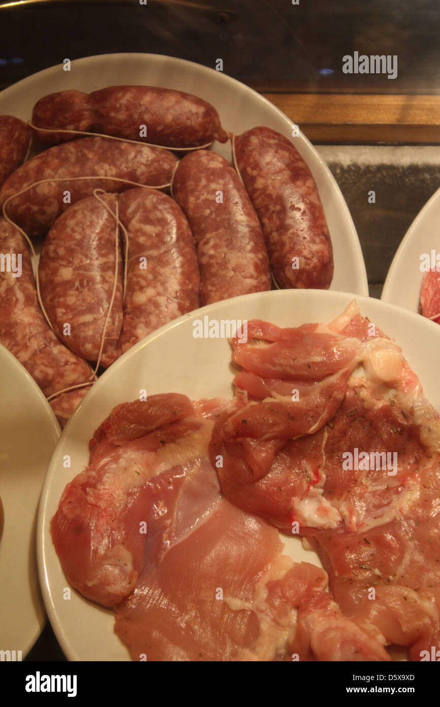 plate of meat and sausages on display outside restaurant window in rome ...