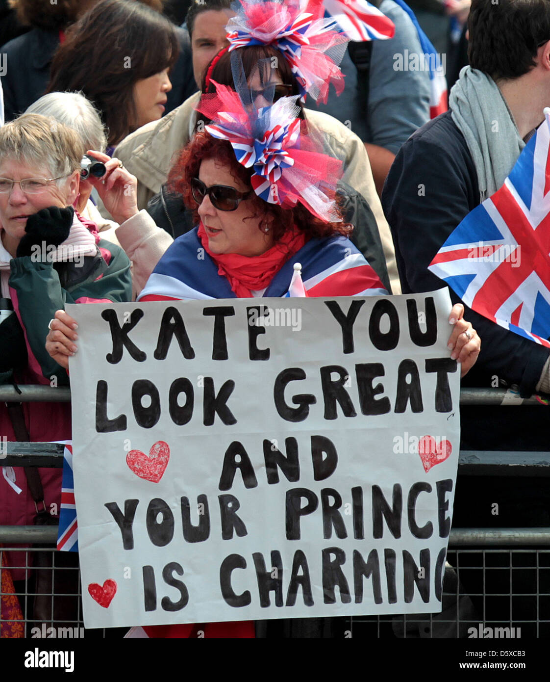 Woman with sign that says 'Kate You Look Great and Your Prince Is ...