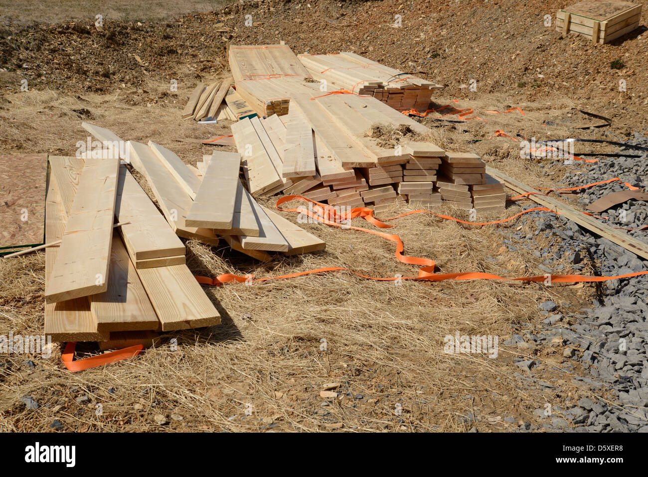 piles of lumber laying on the ground by a construction site Stock Photo ...