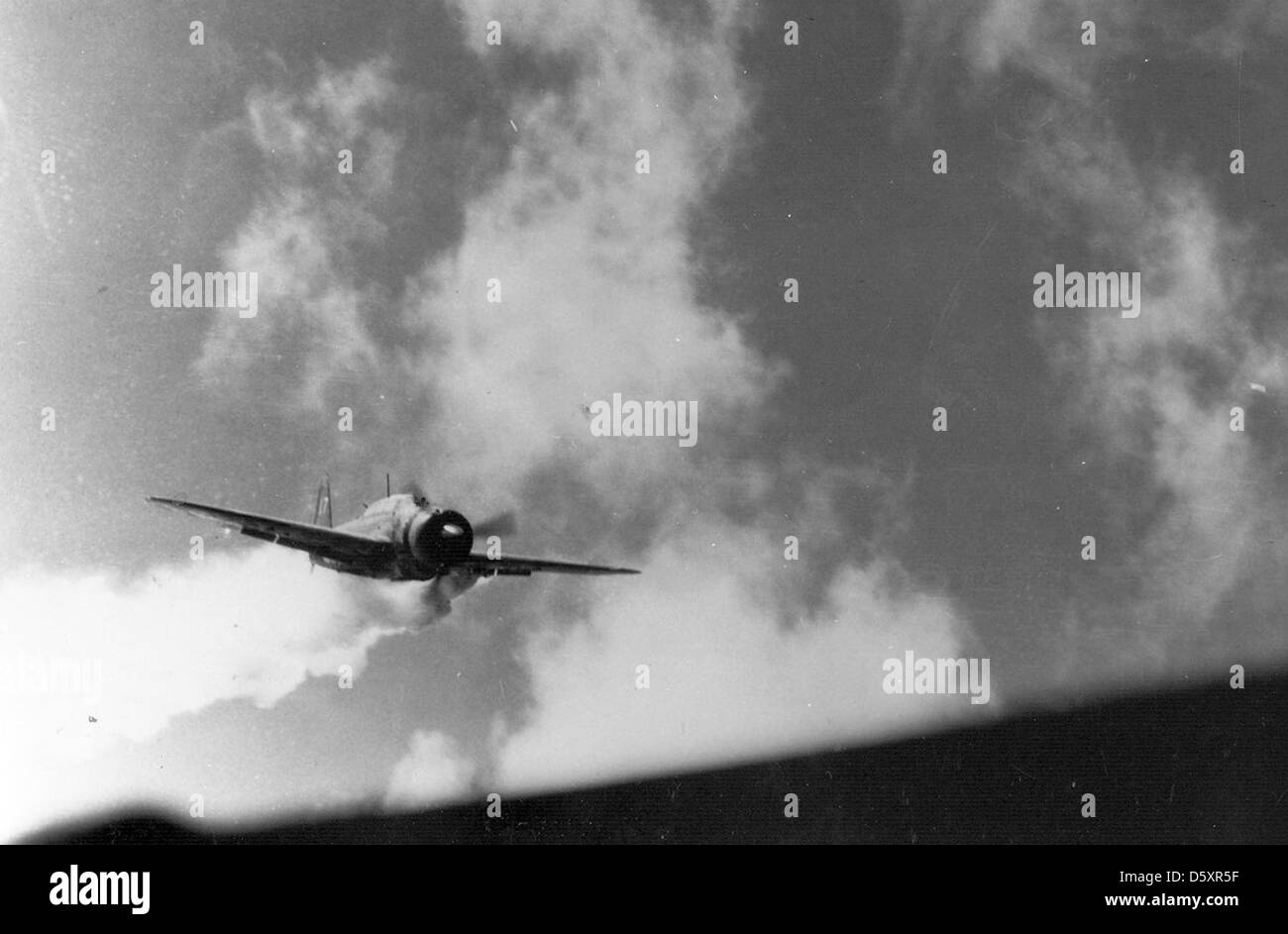 A Japanese kamikaze aircraft, smoking from anti-aircraft hits, veers to ...