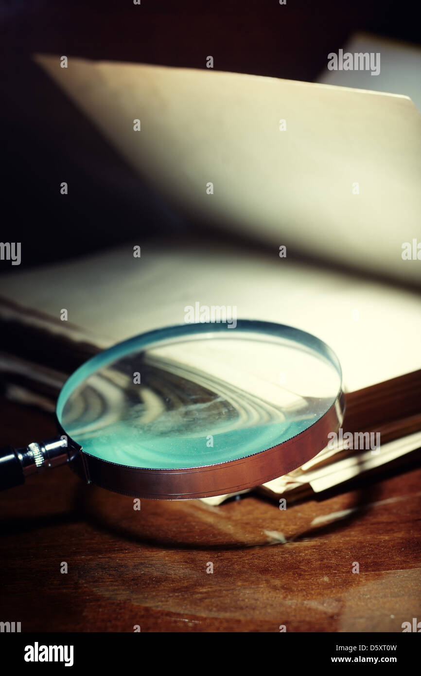 Old book and magnifier Stock Photo - Alamy
