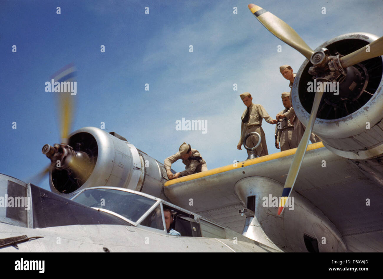 A mechanic works on the engine of a Consolidated PBY 'Catalina' flying ...