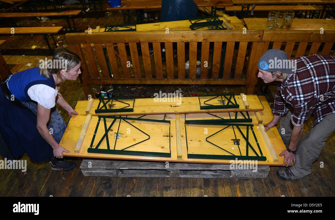 A waitress (L) and a helper carry ale-benches after the Oktoberfest's ...