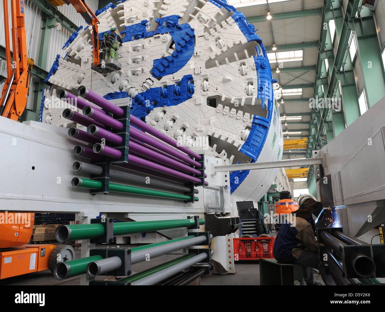 Employees of tunnel boring machine manufacturer Herrenknecht work on a ...