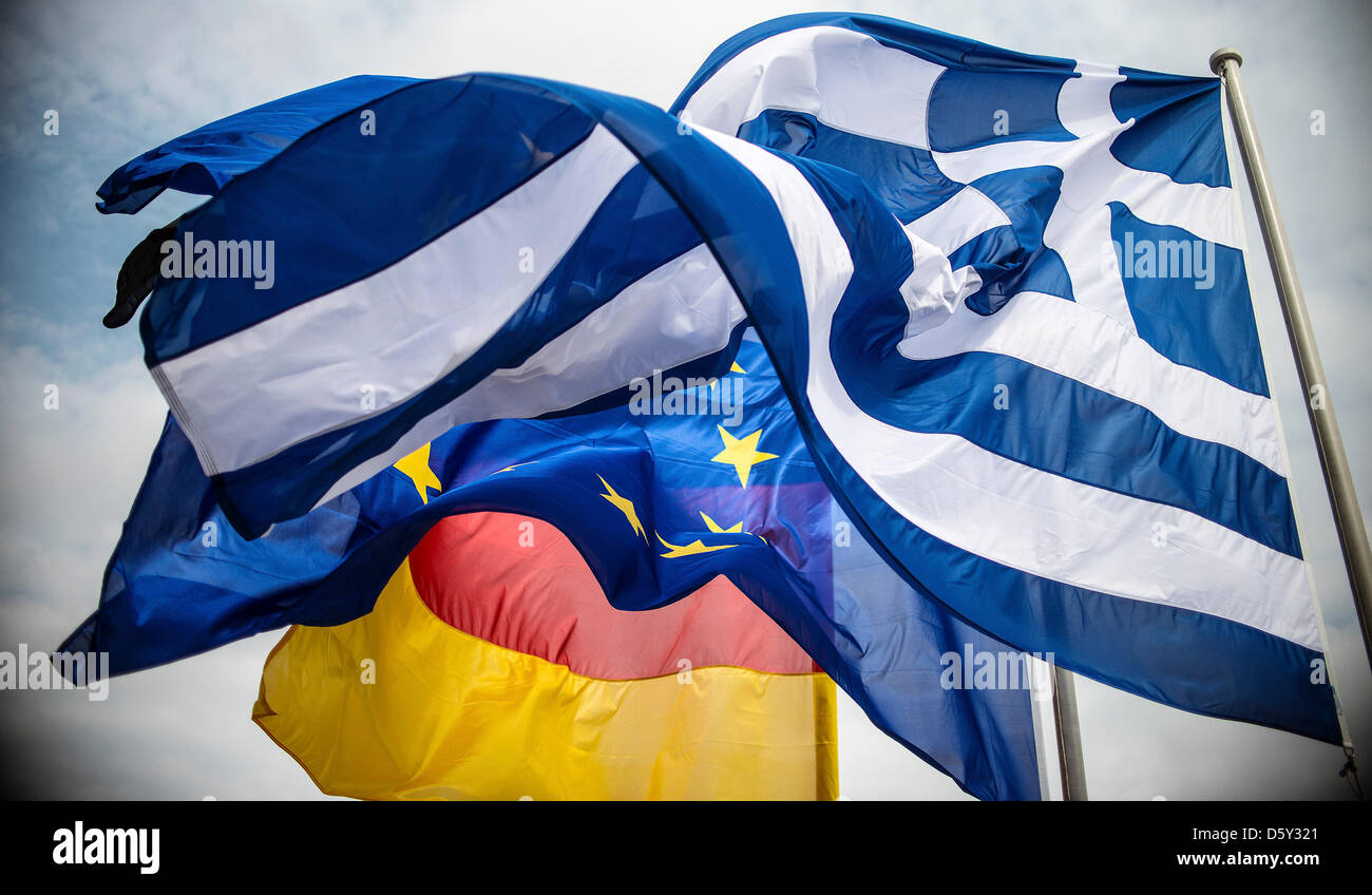 A Greek, European and a German flag wave at the airport of Athens ...