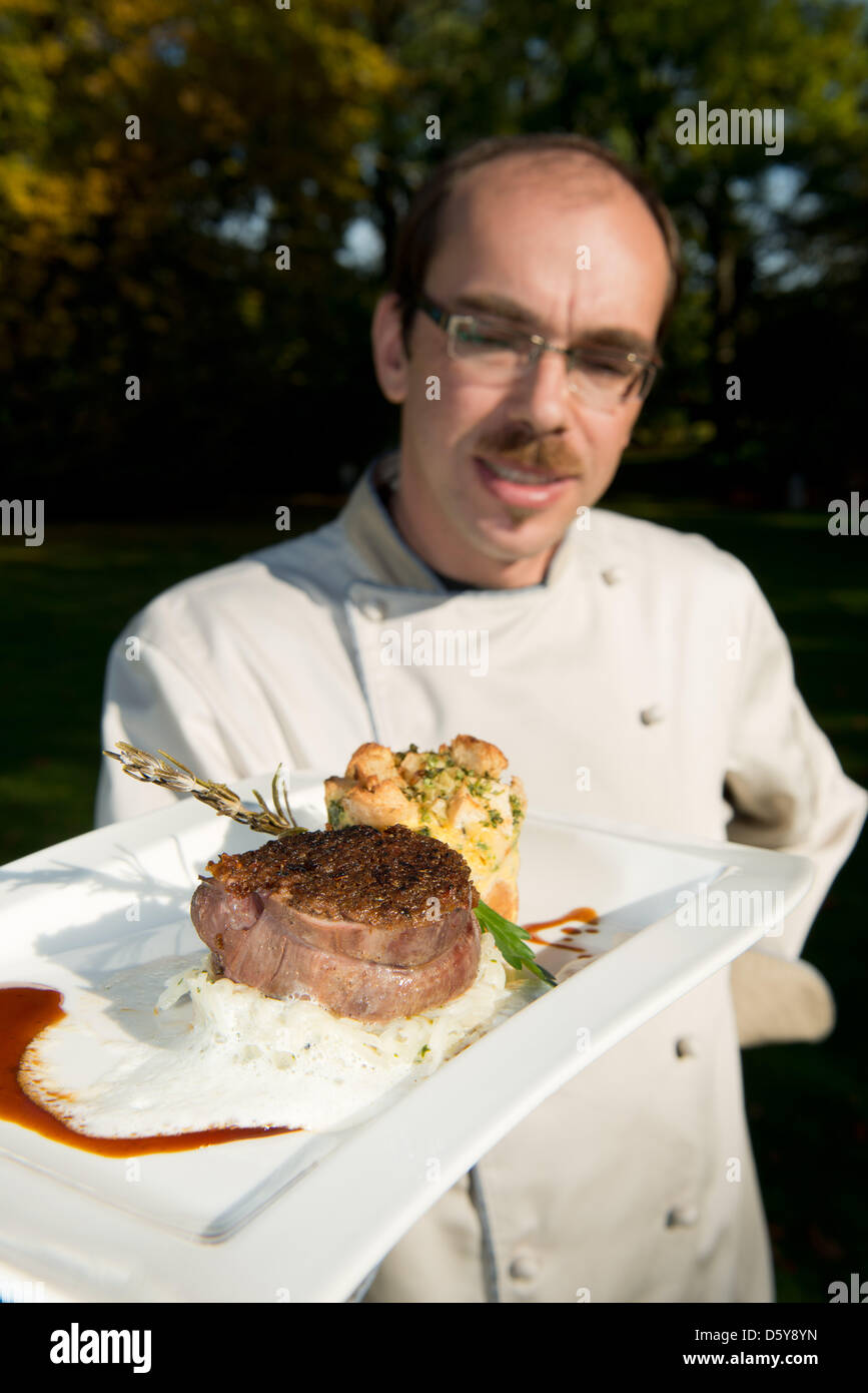 Chef and hotel owner of the manor house, Axel Diembeck, holds a plate ...