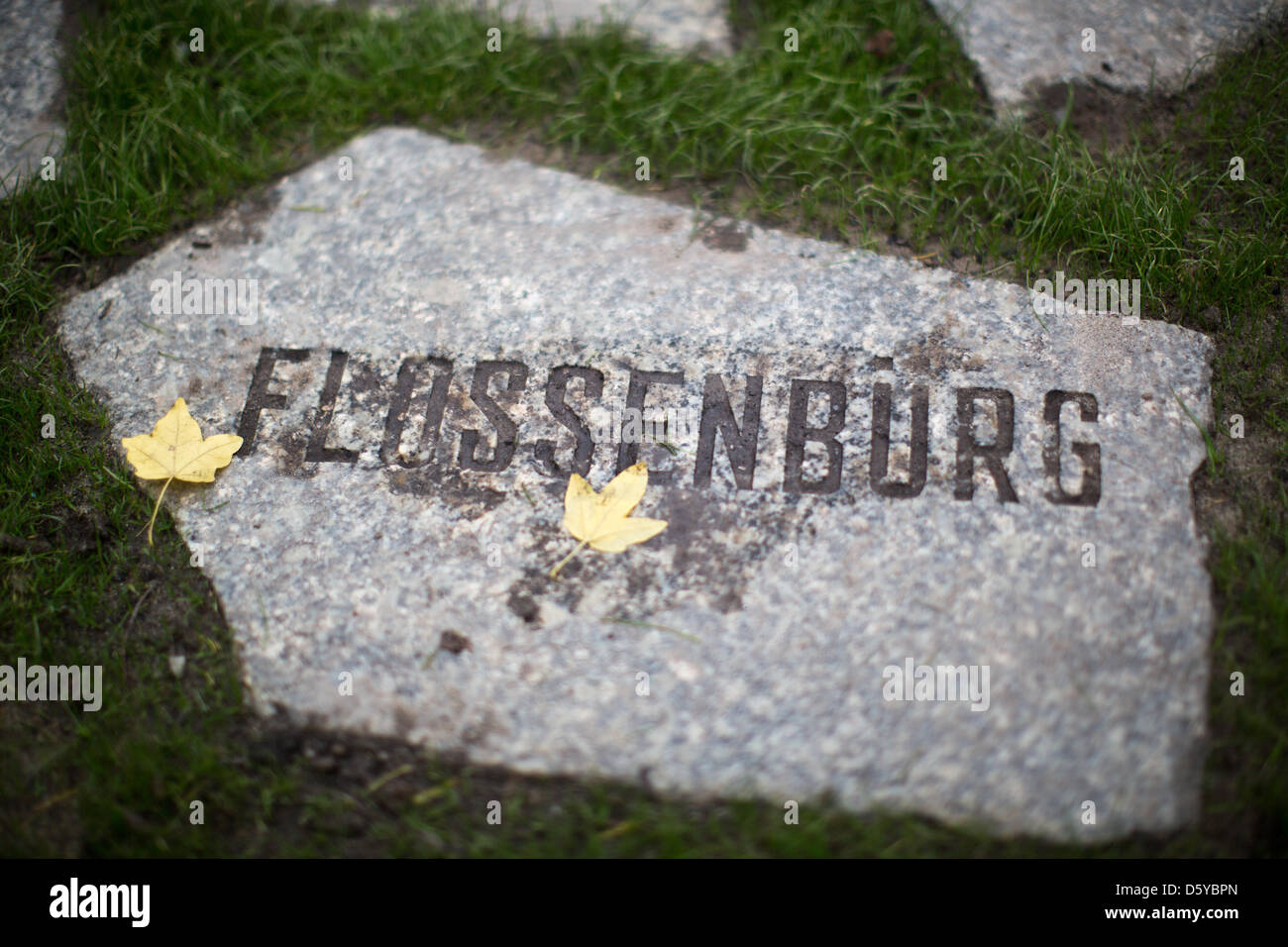 Leaves lie on a stone lettered 'Flossenburg' at the memorial site for ...