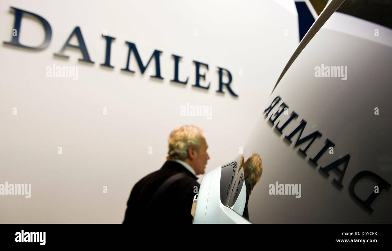The Daimler logo mirrors in the rear window of a car during the company ...