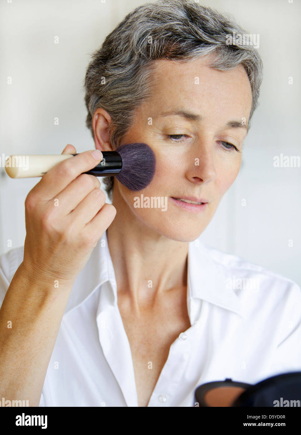 Applying makeup in compact mirror hi-res stock photography and images ...