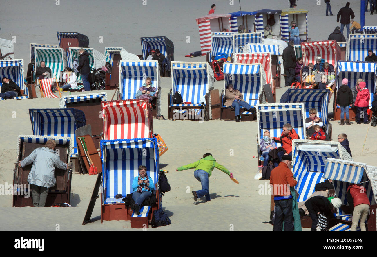Tourists enjoy the beach in whicker beach chairs at the North Sea ...