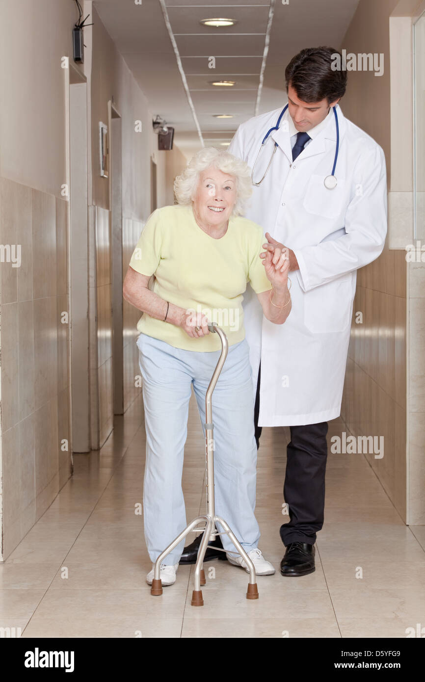 Doctor helping Patient use Walking Stick Stock Photo - Alamy