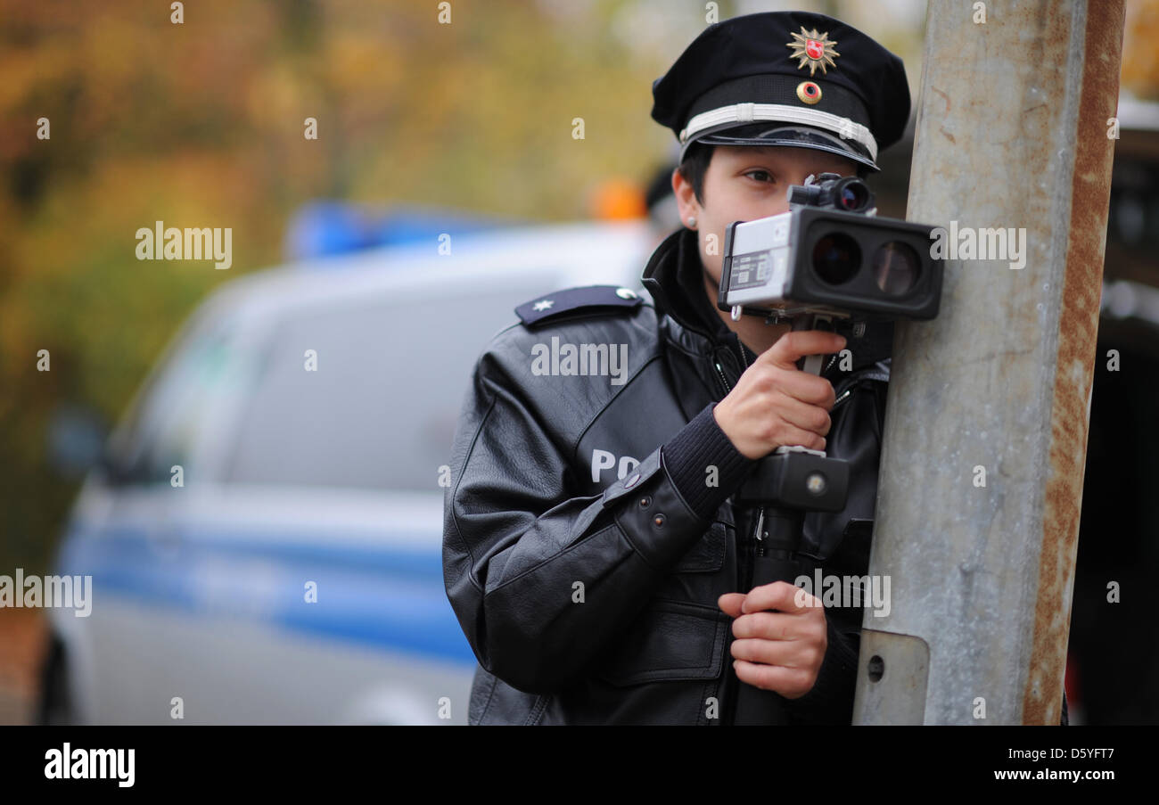 A police officer uses a laser speed measuring device in Hanover ...