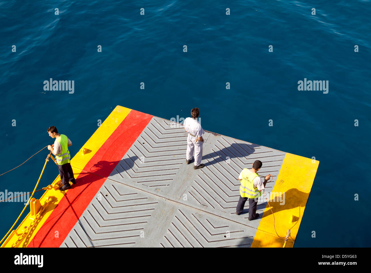 Crew members stand prepared on the landing of the Greek island ferry ...