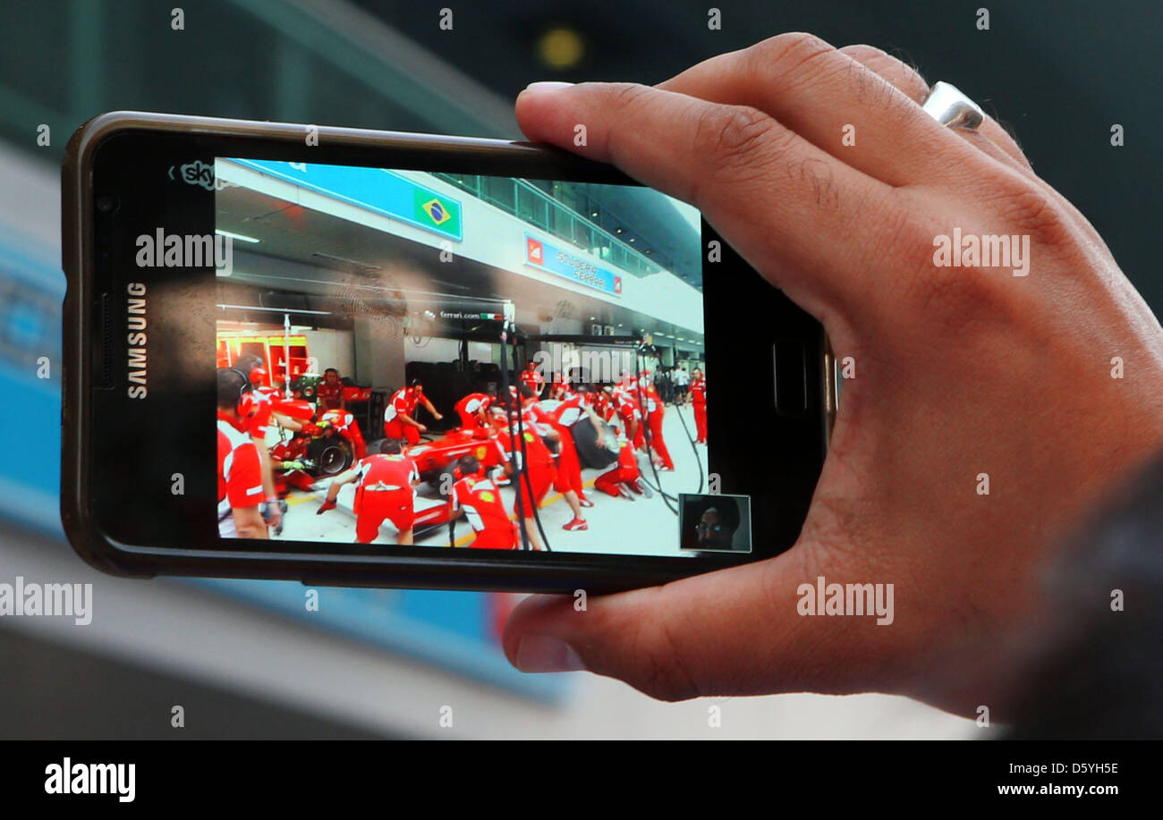 An F1 supportes films with his smartphone the pit stop training of ...