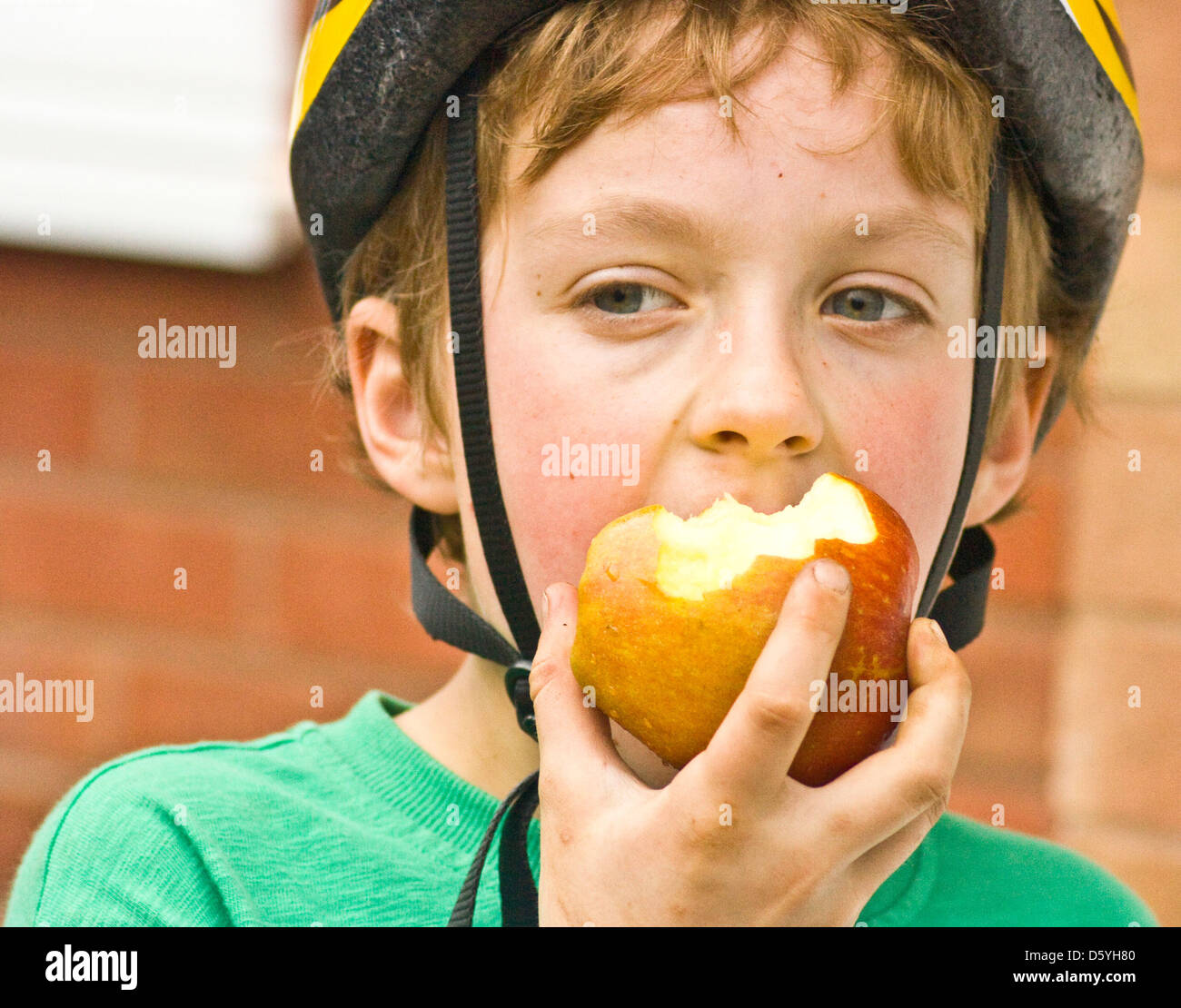 Boy eating biting fresh apple Stock Photo - Alamy