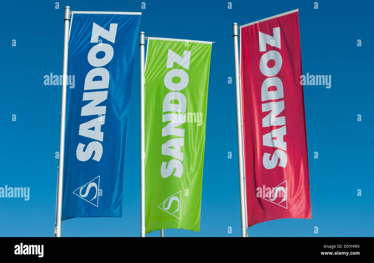 Three colorful flag with "Sandoz" written on them wave in front of a ...