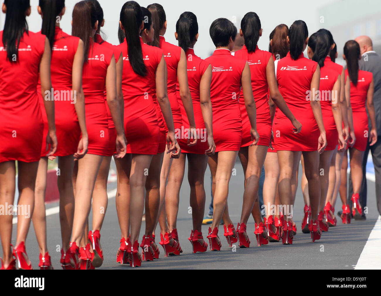 Grid Girls walk in a row through the pit lane after the third practice ...