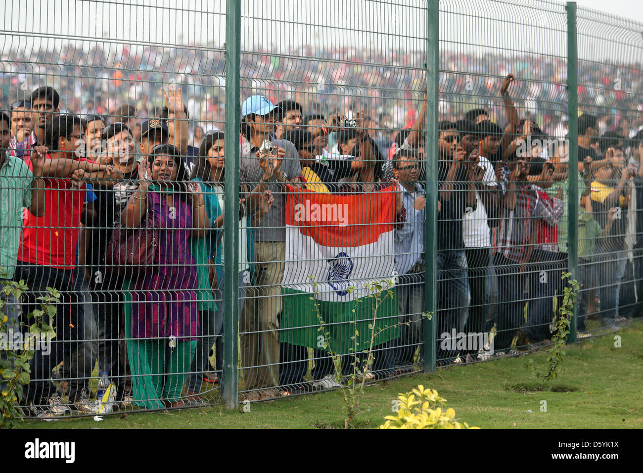 Spectators watch from behind a fence to start of the Formula One Grand ...