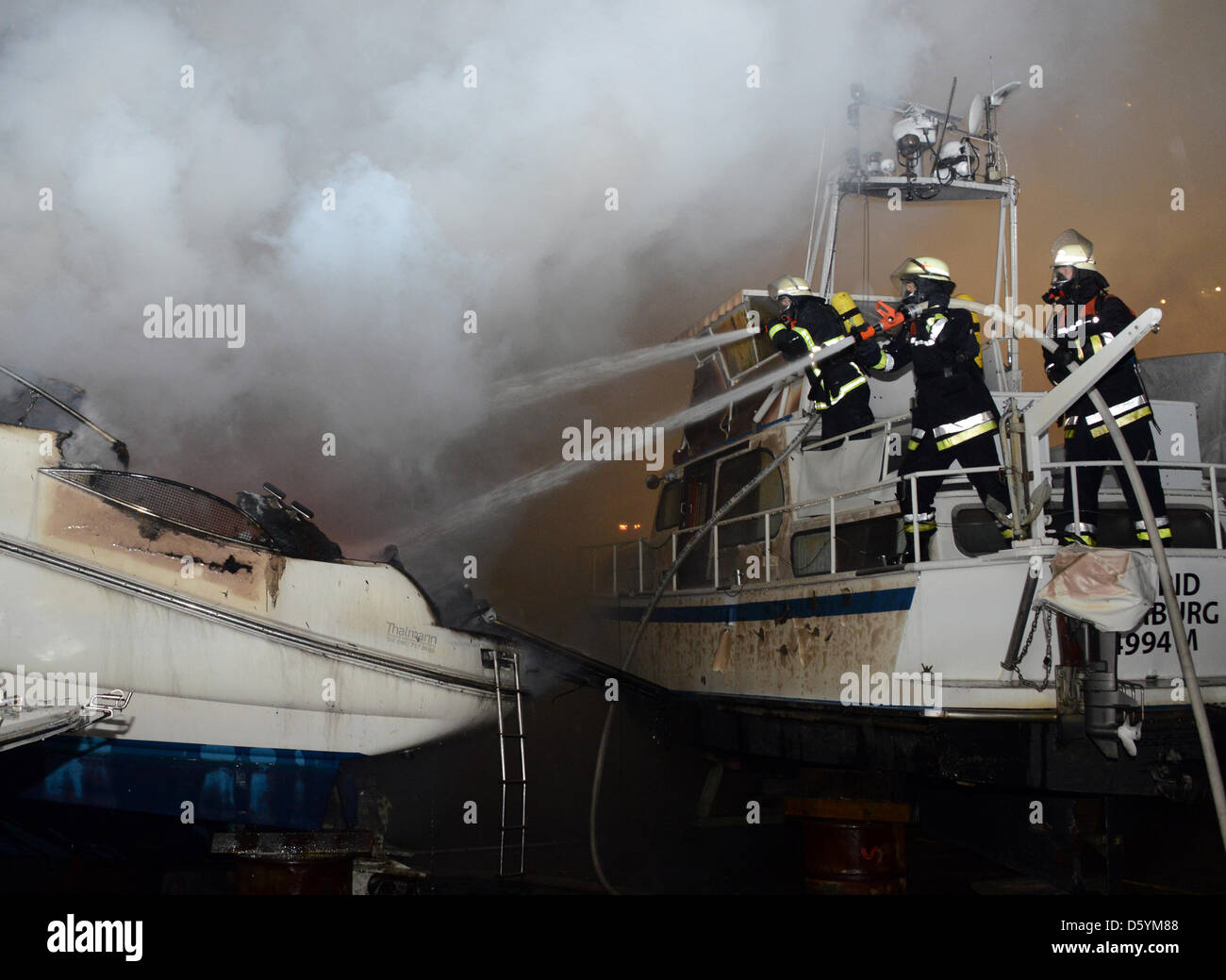 Firefighters extinguish a fire in a sports yacht in Hamburg, Germany ...