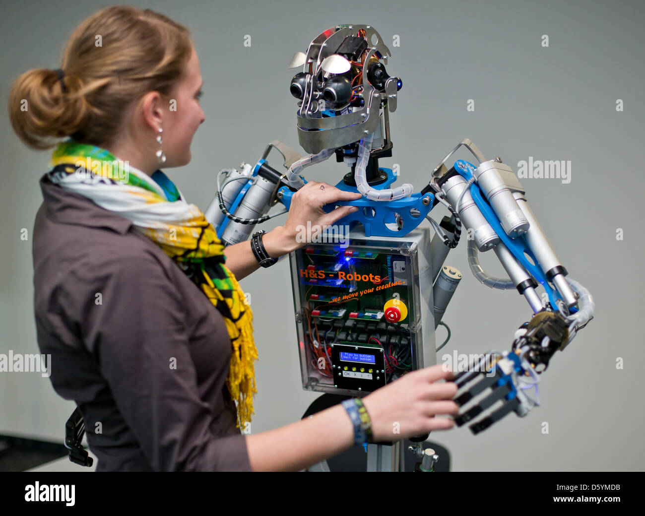 A woman poses with a humanoid robot at the Invention trade fair IENA in ...