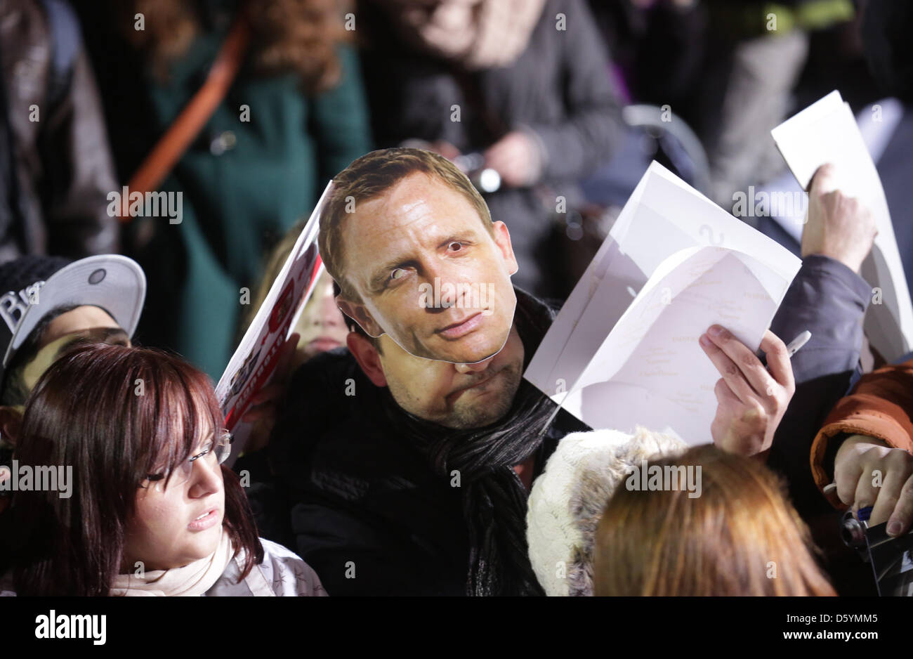 A fan with a mask of British actor Daniel Craig and other fans await ...